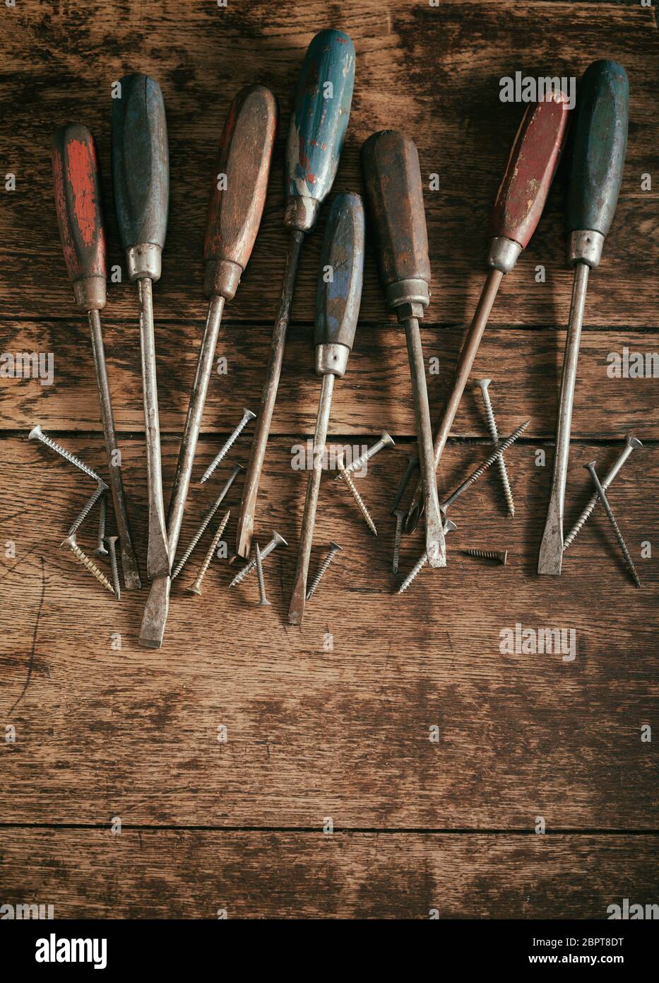 Old vintage screwdrivers with wooden handles arranged in a line as a ...