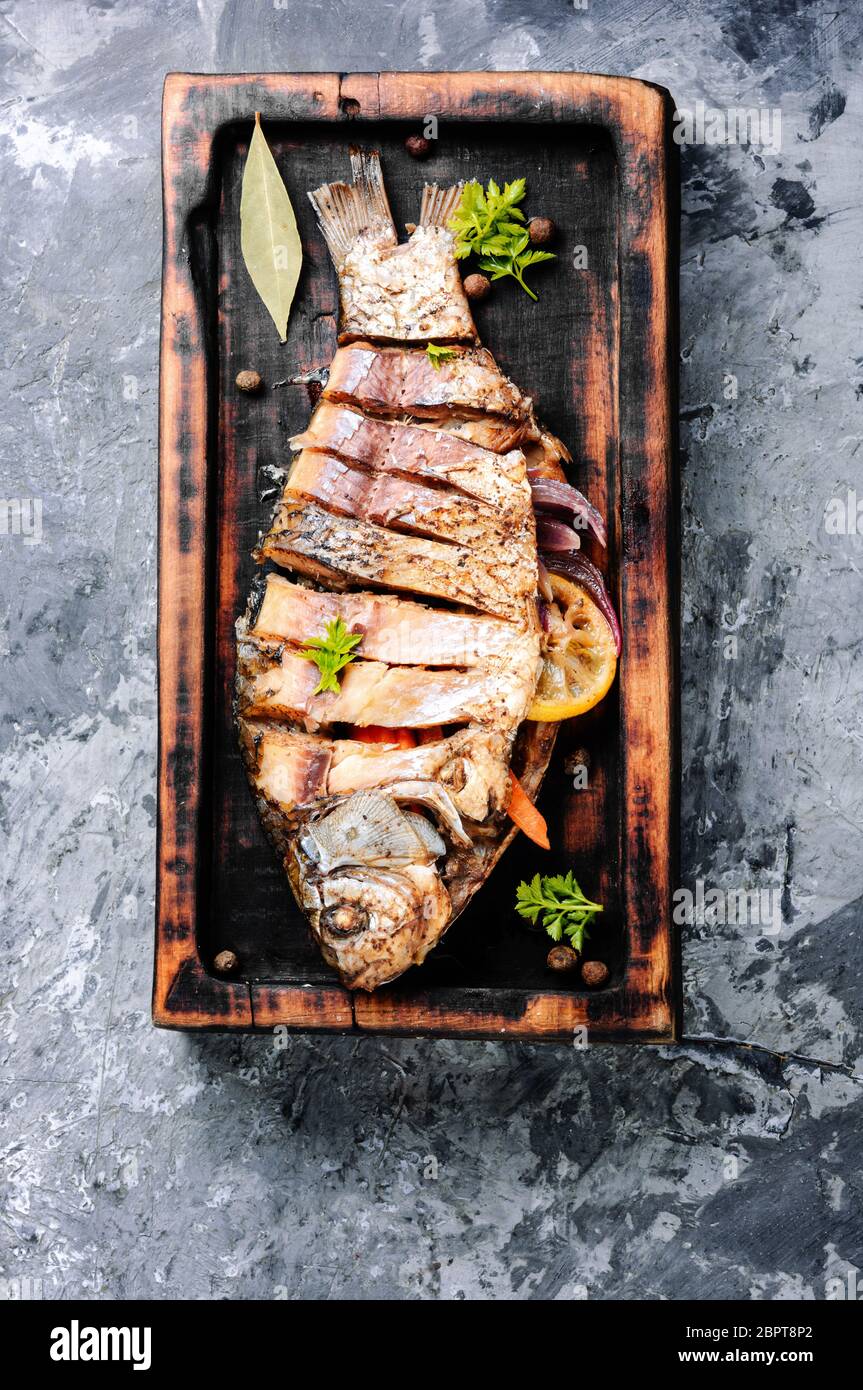 Grilled whole fish with citrus,vegetable and spices on rustic kitchen ...