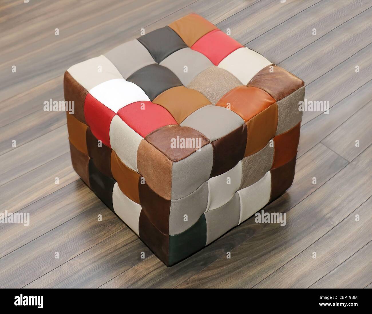 Small footstool furniture with colorful leather upholstery on wooden ...