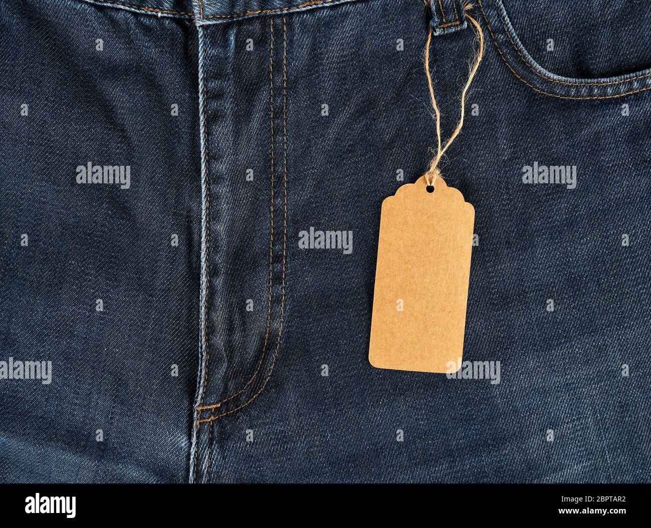 empty brown tag tied on a rope to blue jeans, full frame Stock Photo ...