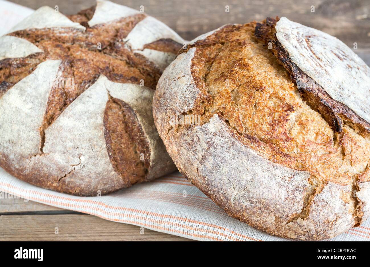 Two loaves of bread on the old-fashioned background Stock Photo - Alamy