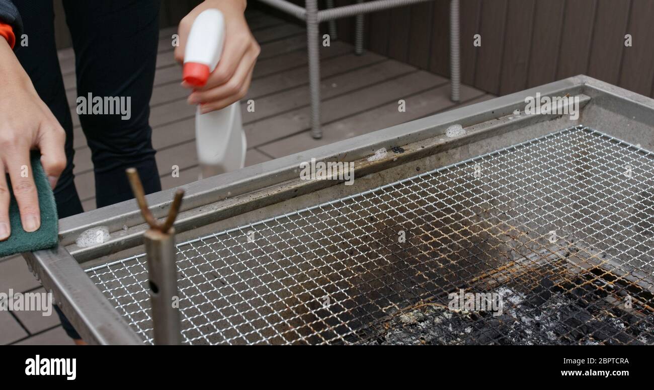 Woman wash the BBQ oven Stock Photo - Alamy