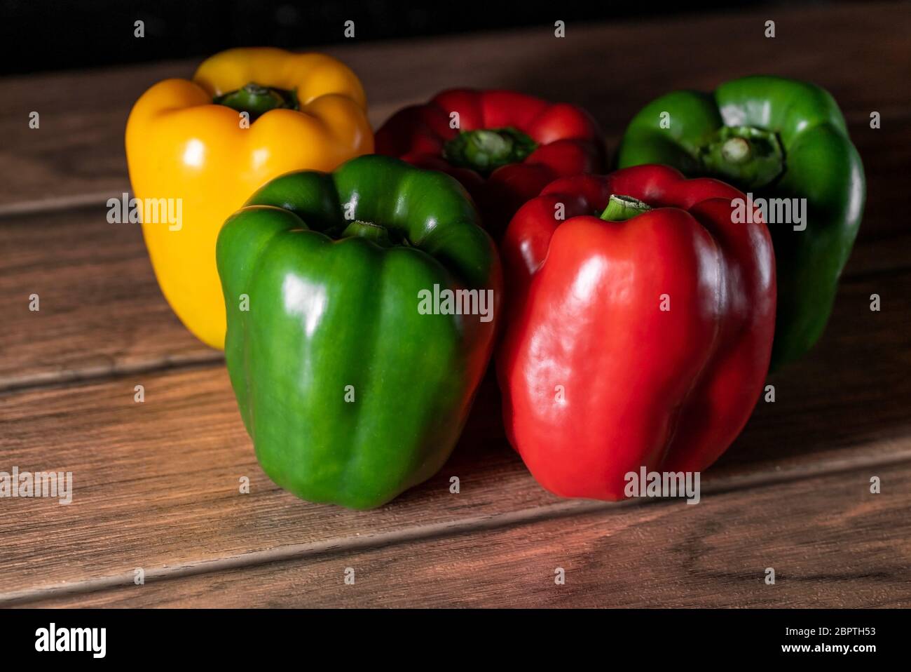six large fresh bell peppers different colors on a wooden board Stock ...