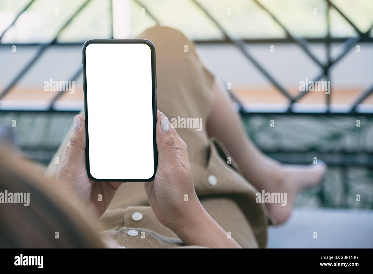 Mockup image of a woman holding black mobile phone with blank white ...