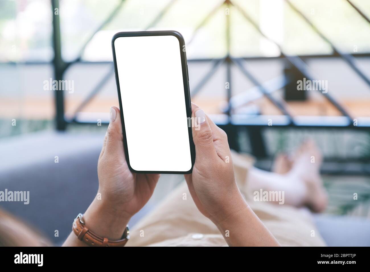 Mockup image of a woman holding black mobile phone with blank white ...
