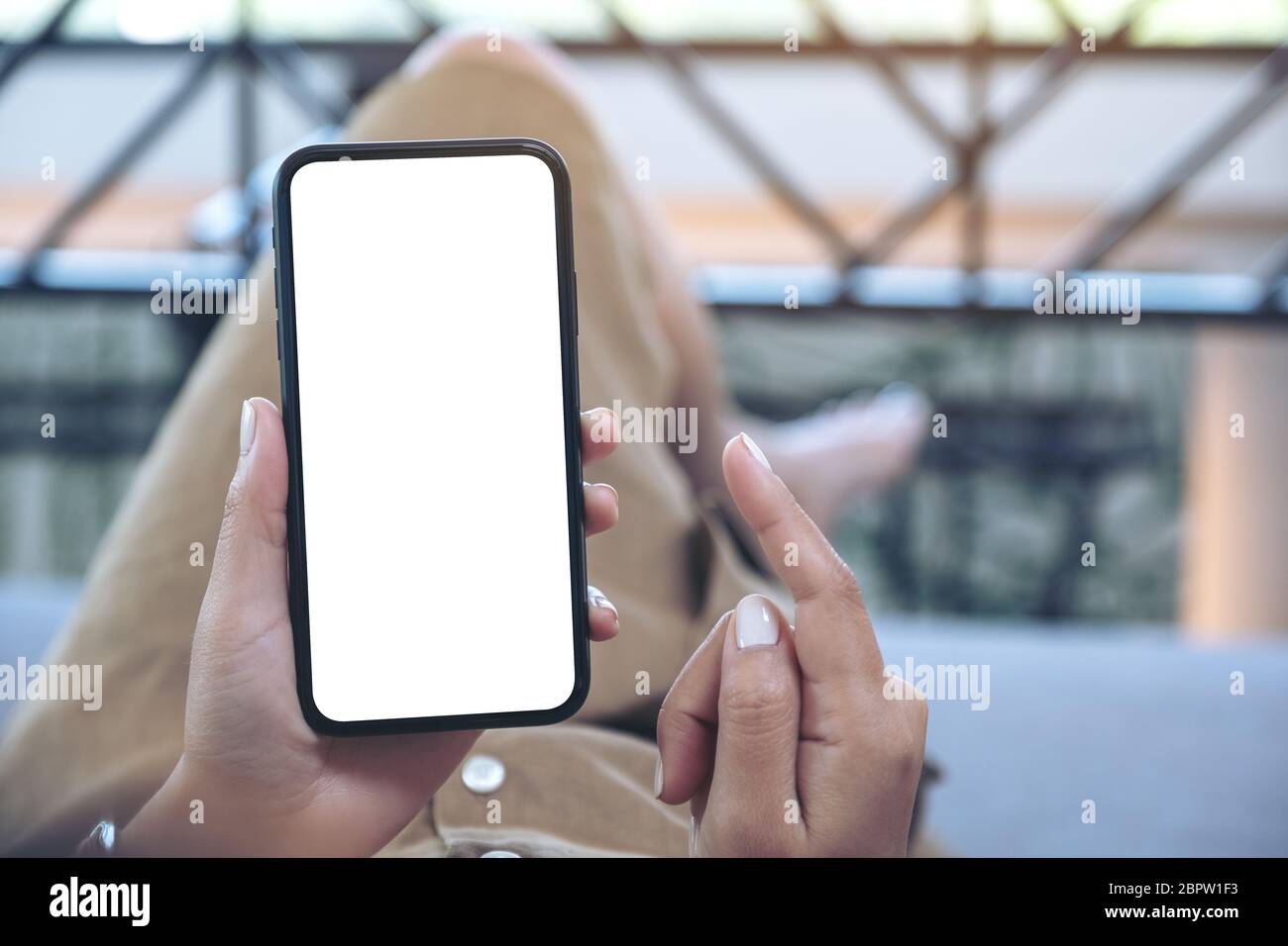 Mockup image of a woman holding black mobile phone with blank white ...
