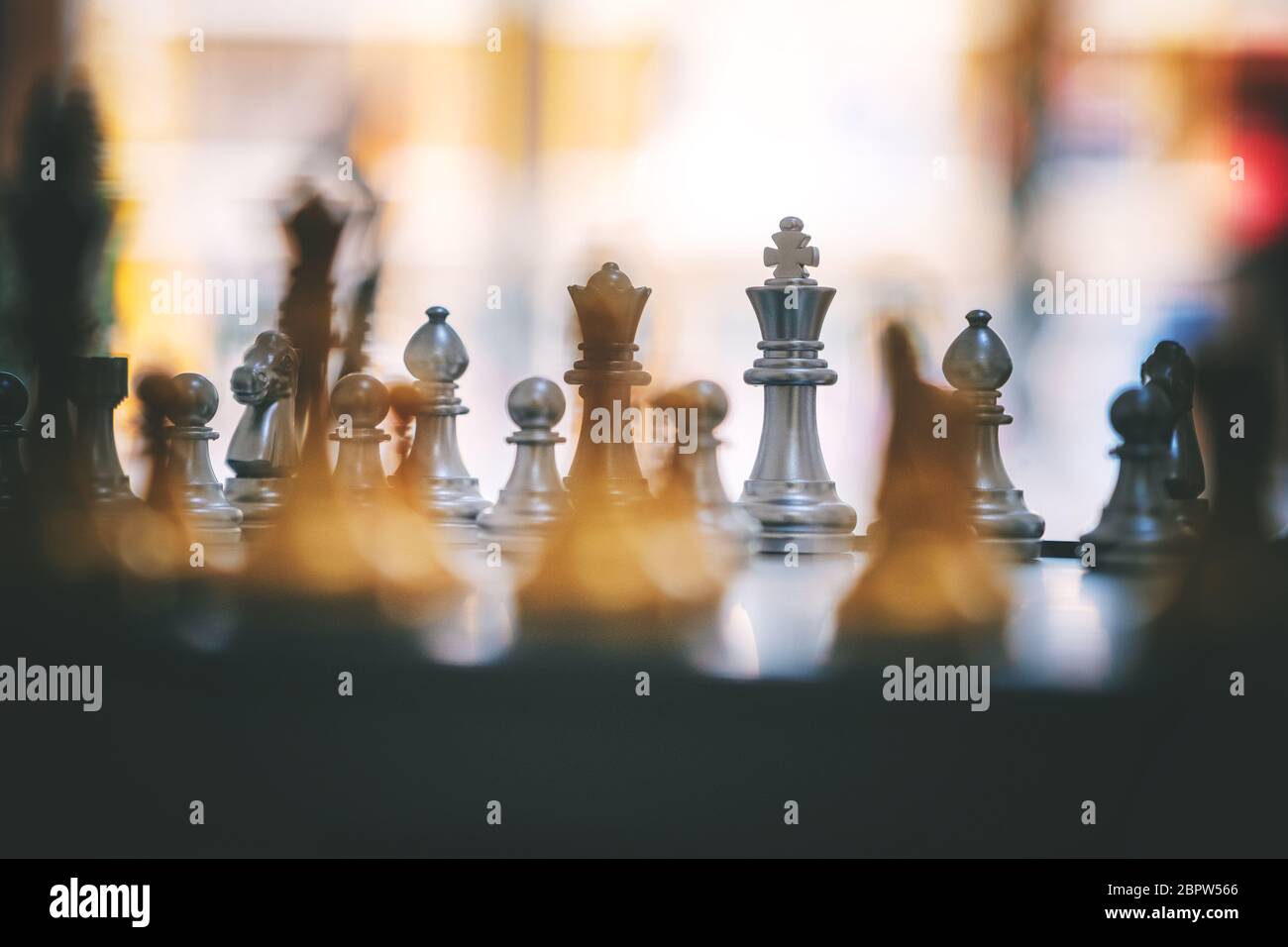 Closeup image of a silver and golden color chess set on chessboard ...