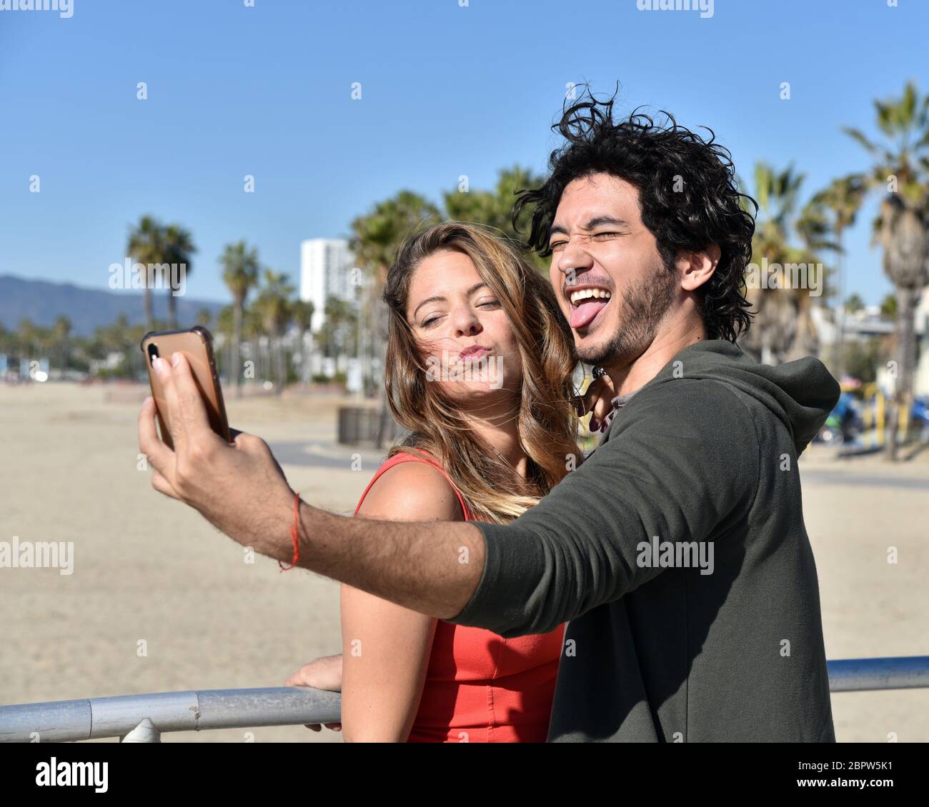 Romantic couple taking cell phone photos in a tropical beach town Stock ...