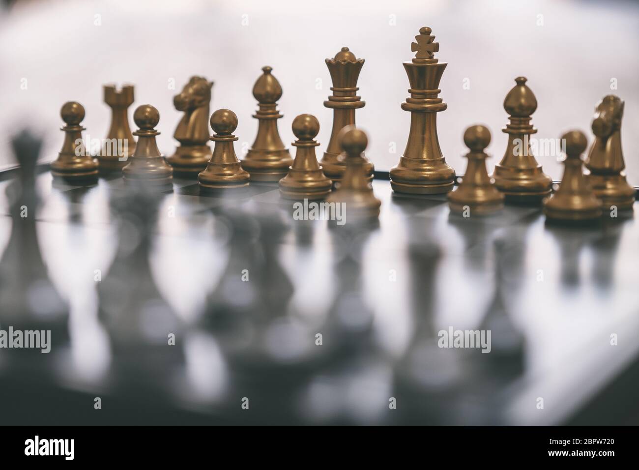 Closeup image of a silver and golden color chess set on chessboard ...