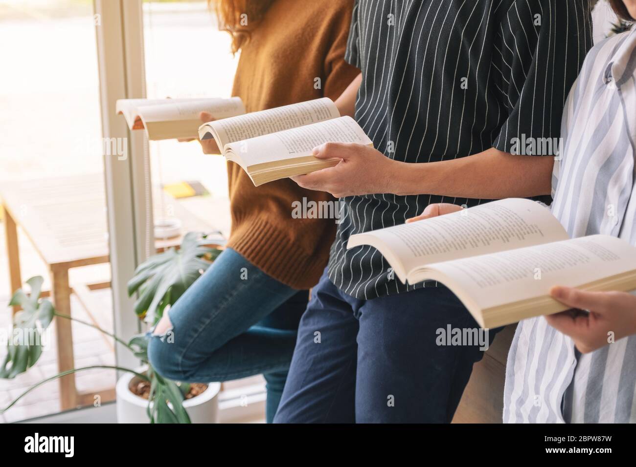 Three young people enjoyed reading books together Stock Photo - Alamy