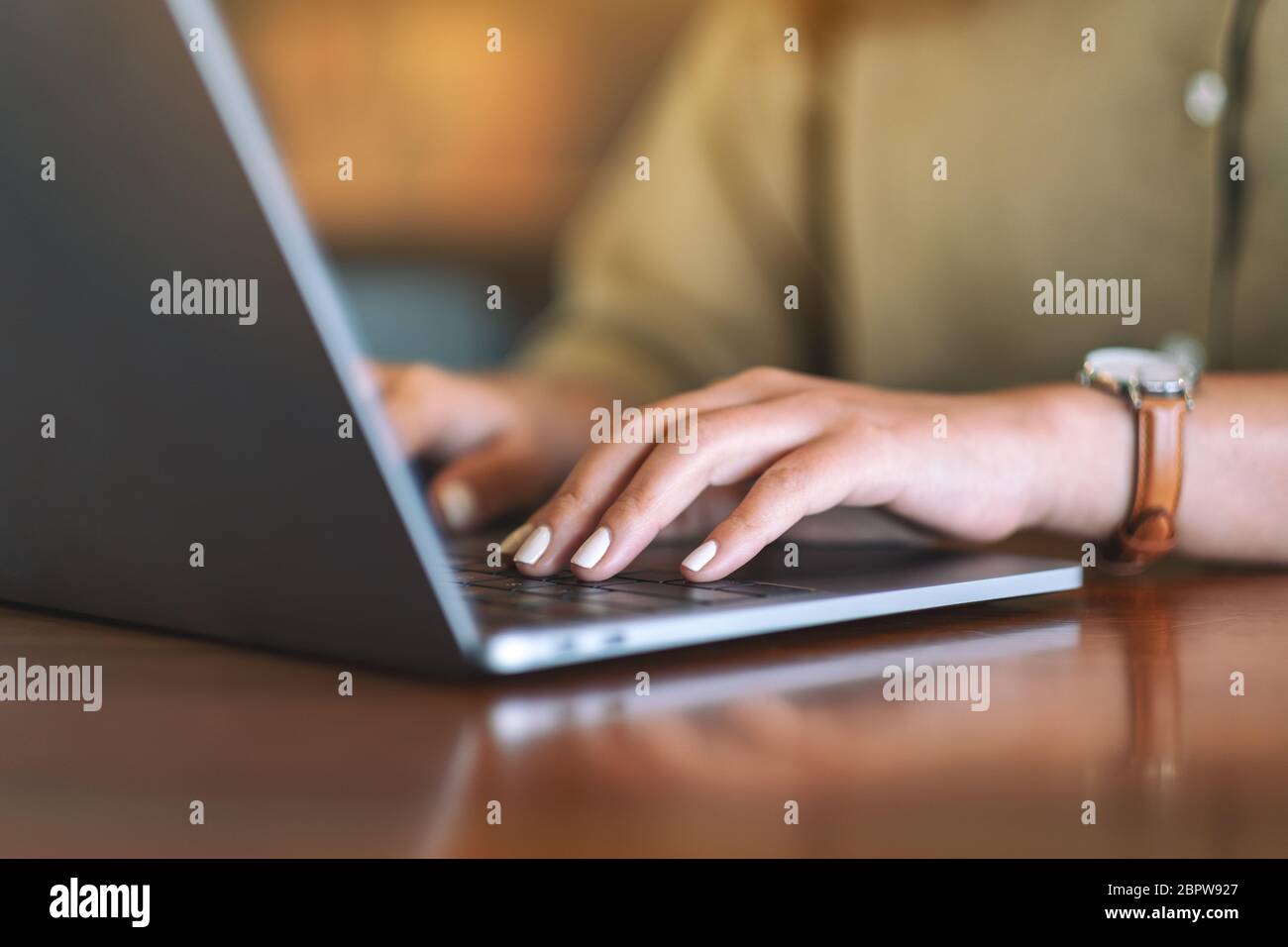 Closeup image of woman's hands using and typing on laptop computer ...