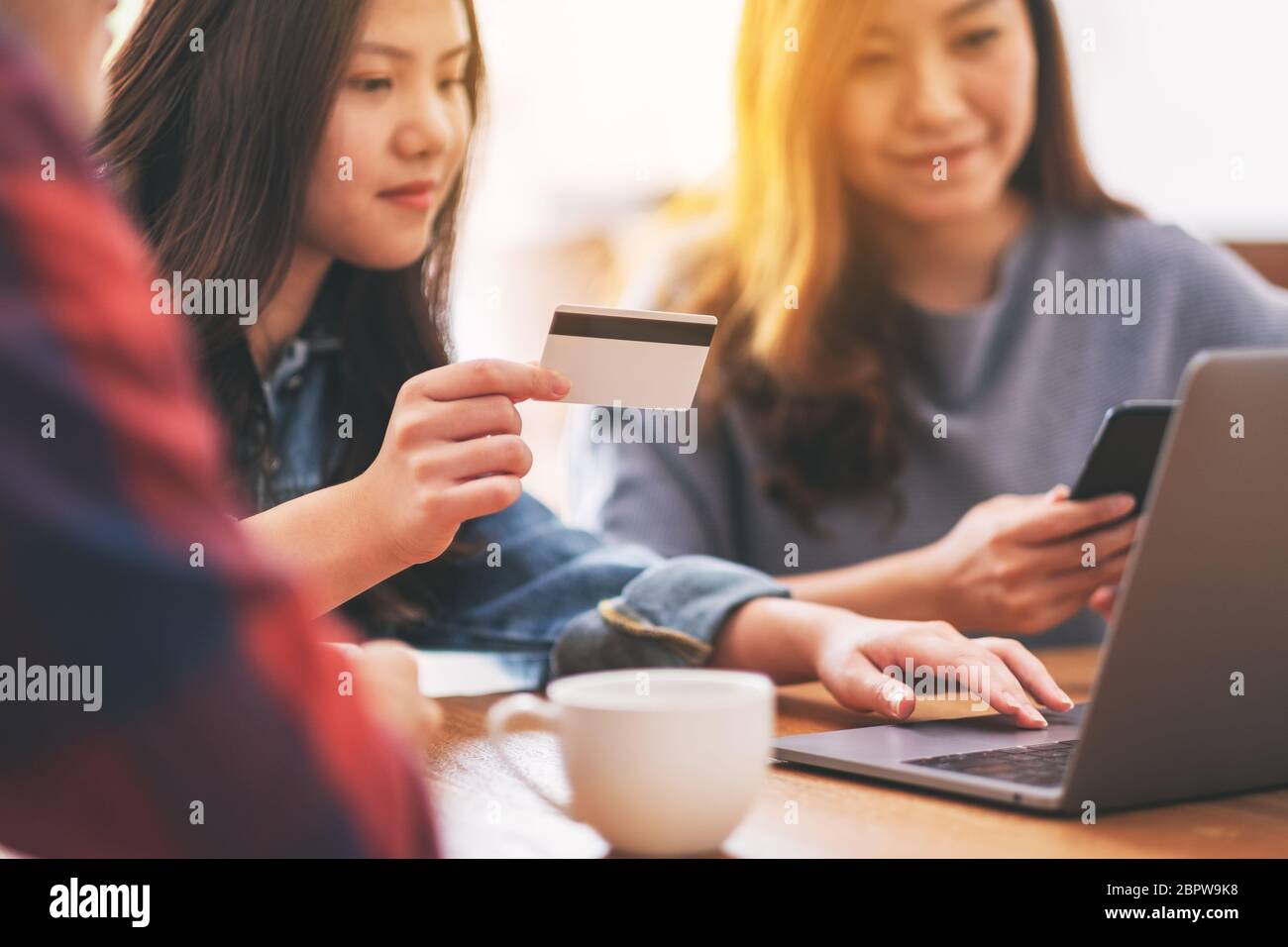 Three young asian people use credit card for purchasing and shopping ...