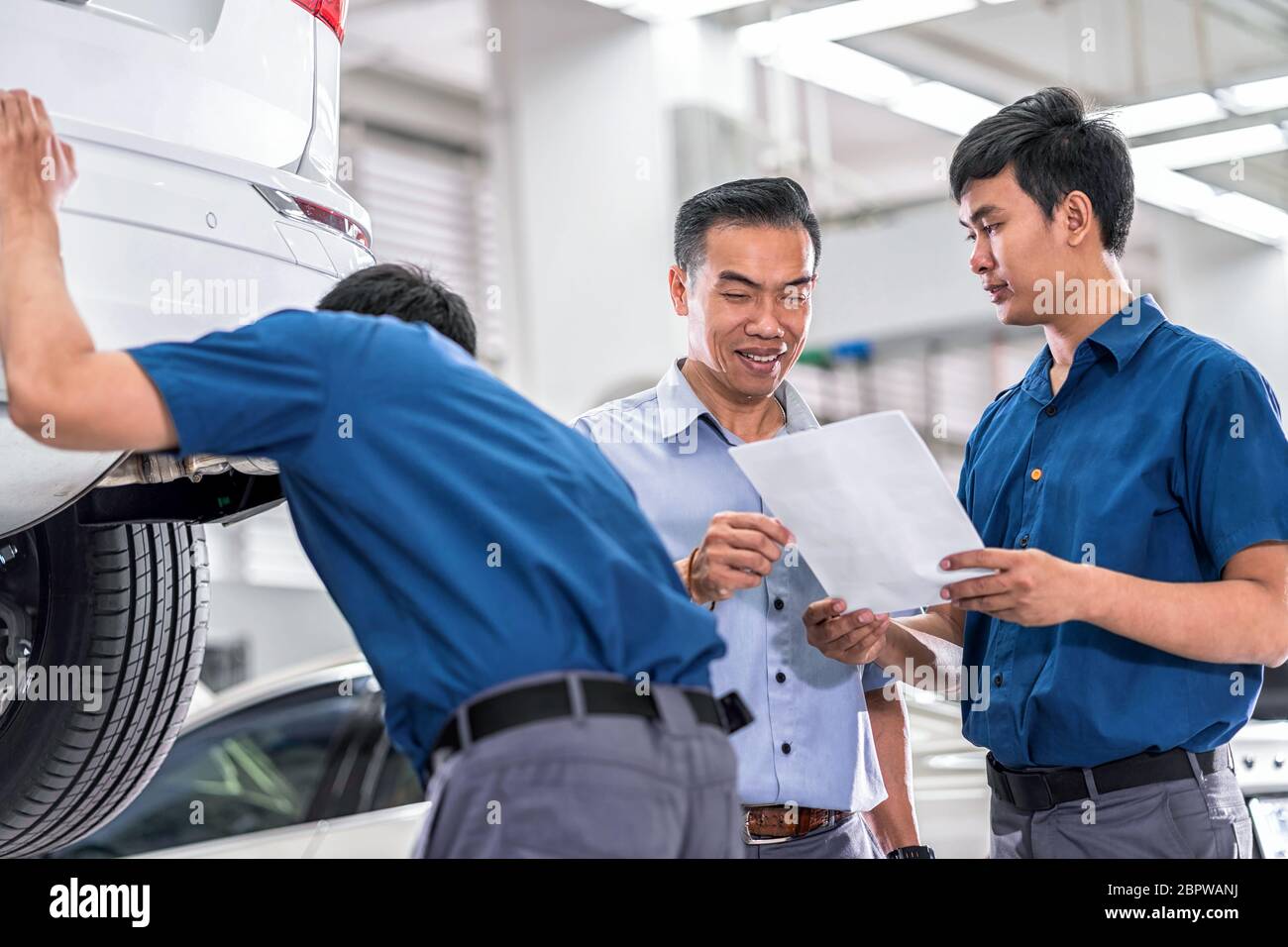 Asian Mechanic talking and showing job to the customer about repair ...