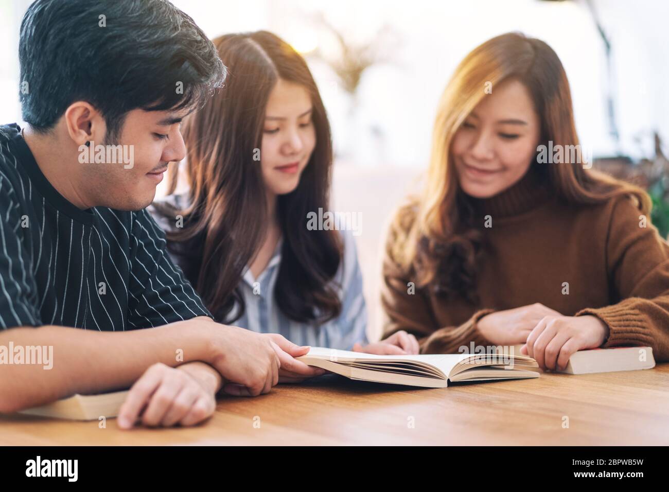 Group of young people enjoyed reading the same book together Stock ...