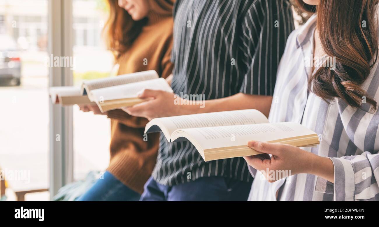 Three young people standing and enjoyed reading books together Stock ...