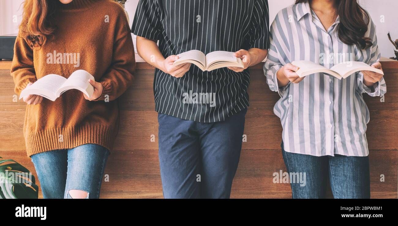 Three young people standing and enjoyed reading books together Stock ...