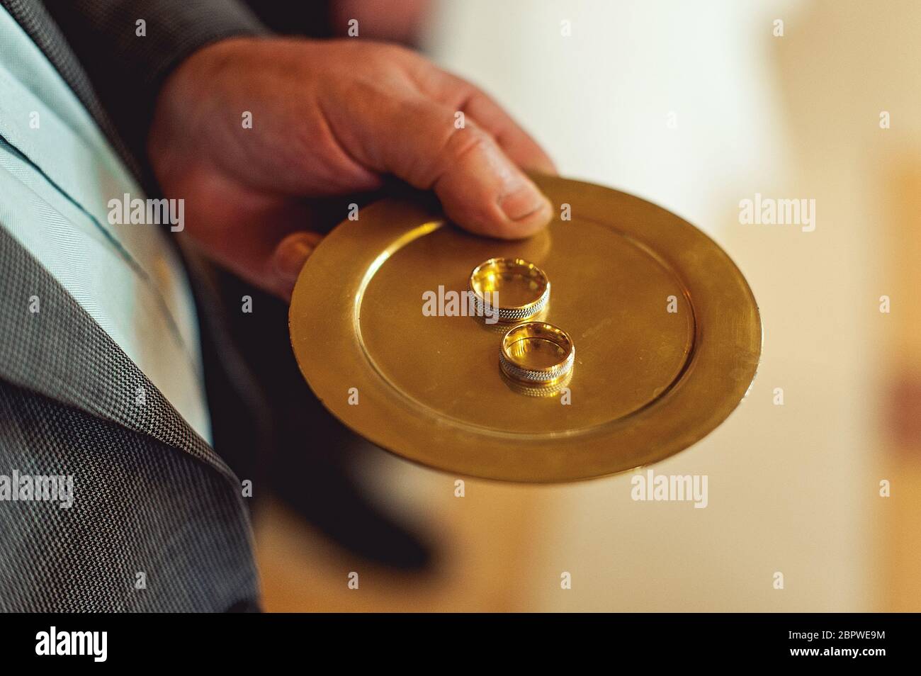 Classic gold wedding ring on a gold plate Stock Photo - Alamy