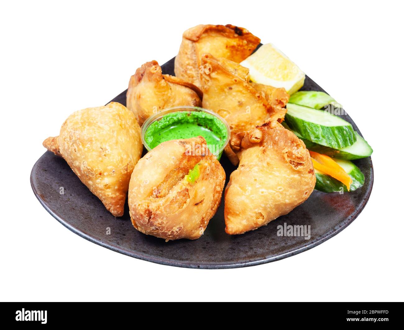 Indian cuisine - many samosas (fried savoury pastry) on black plate ...