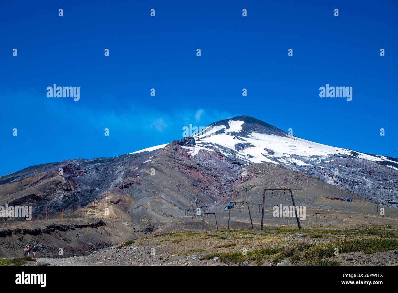 The slope of the volcano Villarrica with a cable car against the blue ...