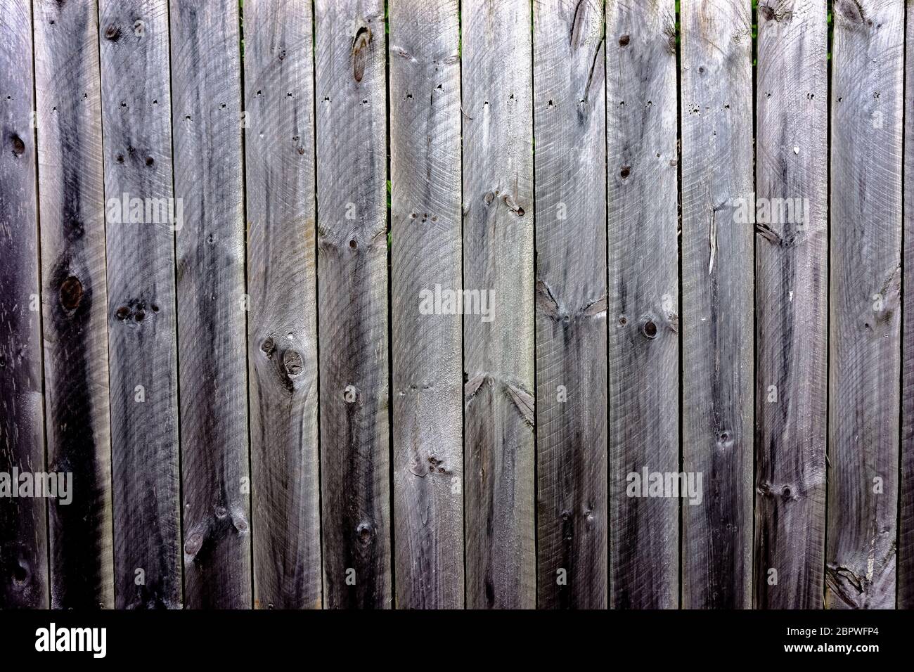 Old weathered wooden fence surface with varried texture and coloration ...