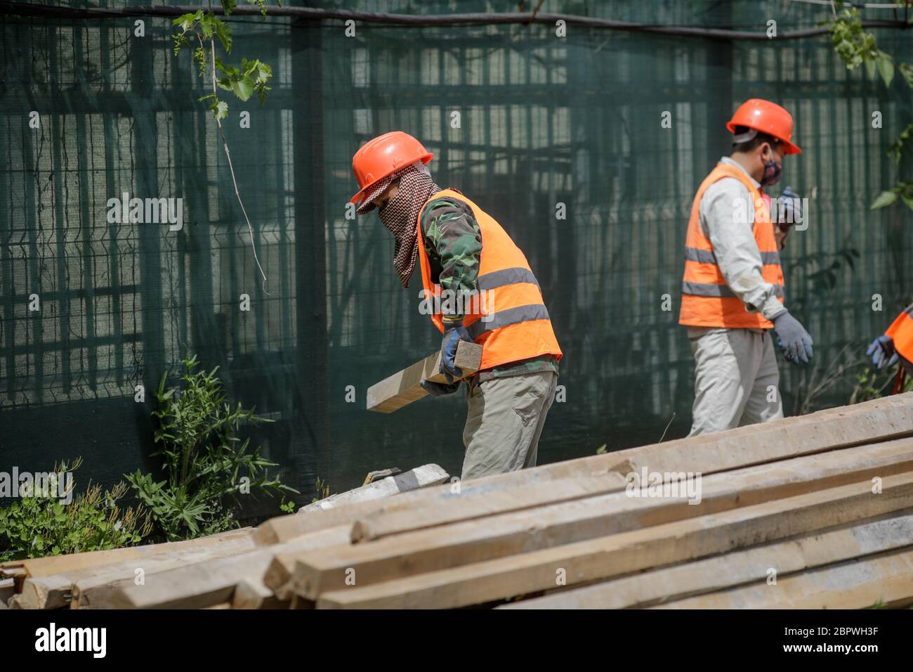 Bucharest, Romania - May 14, 2020: Asian construction workers on a construction site in ...