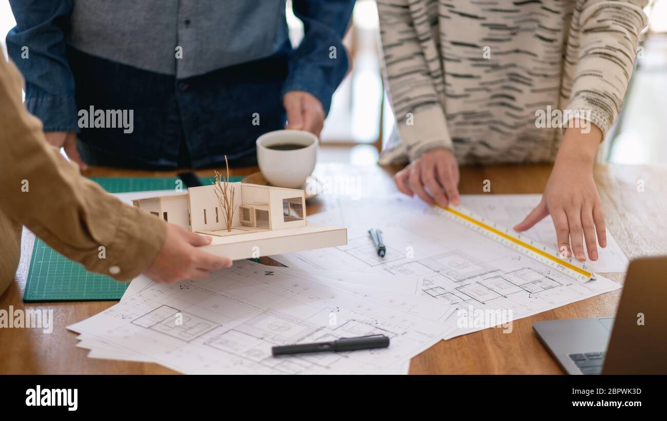 Group of an architect working and measuring scale of a mass model on ...