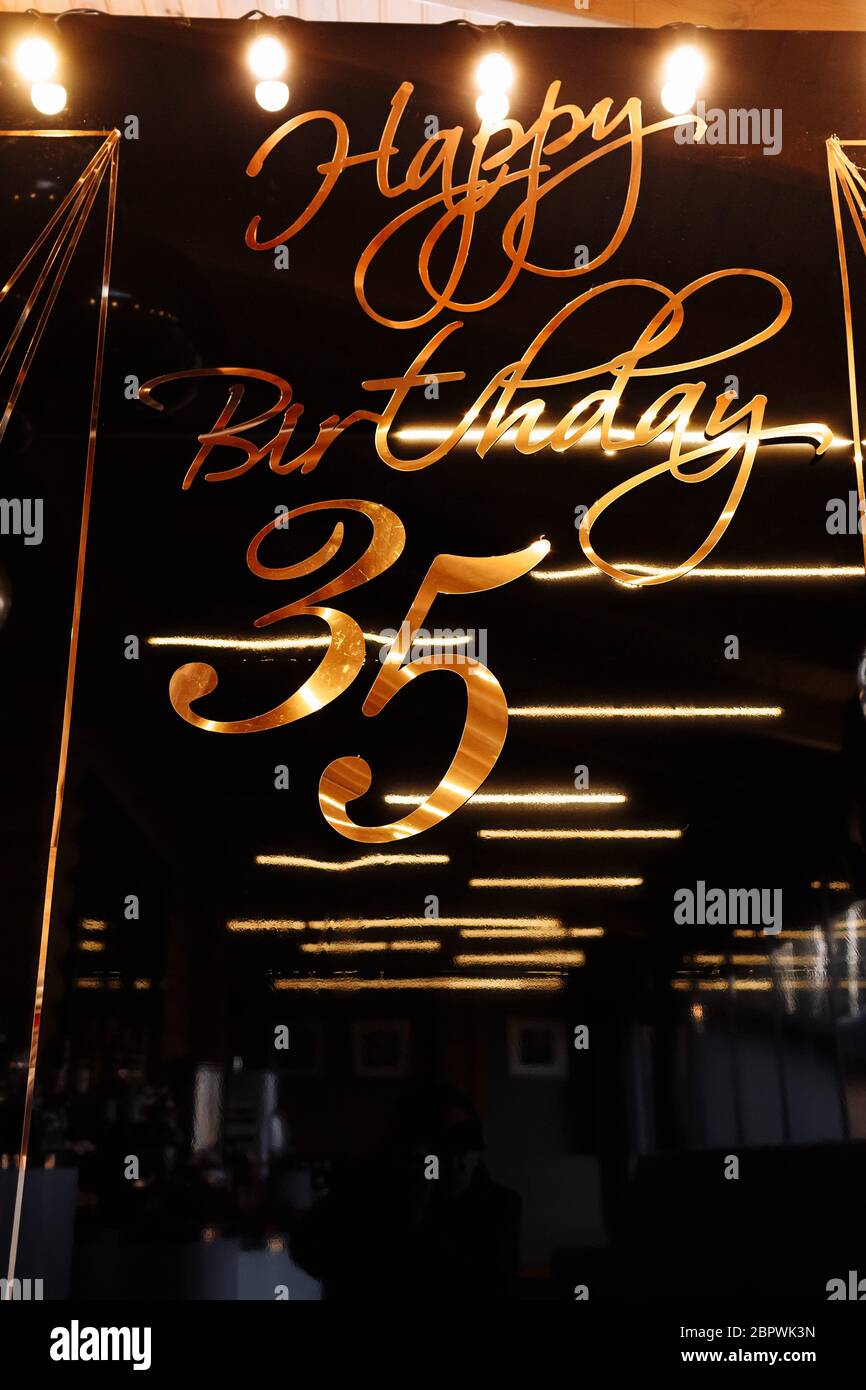 decor to the 35th anniversary. black wall with a gold inscription happy ...