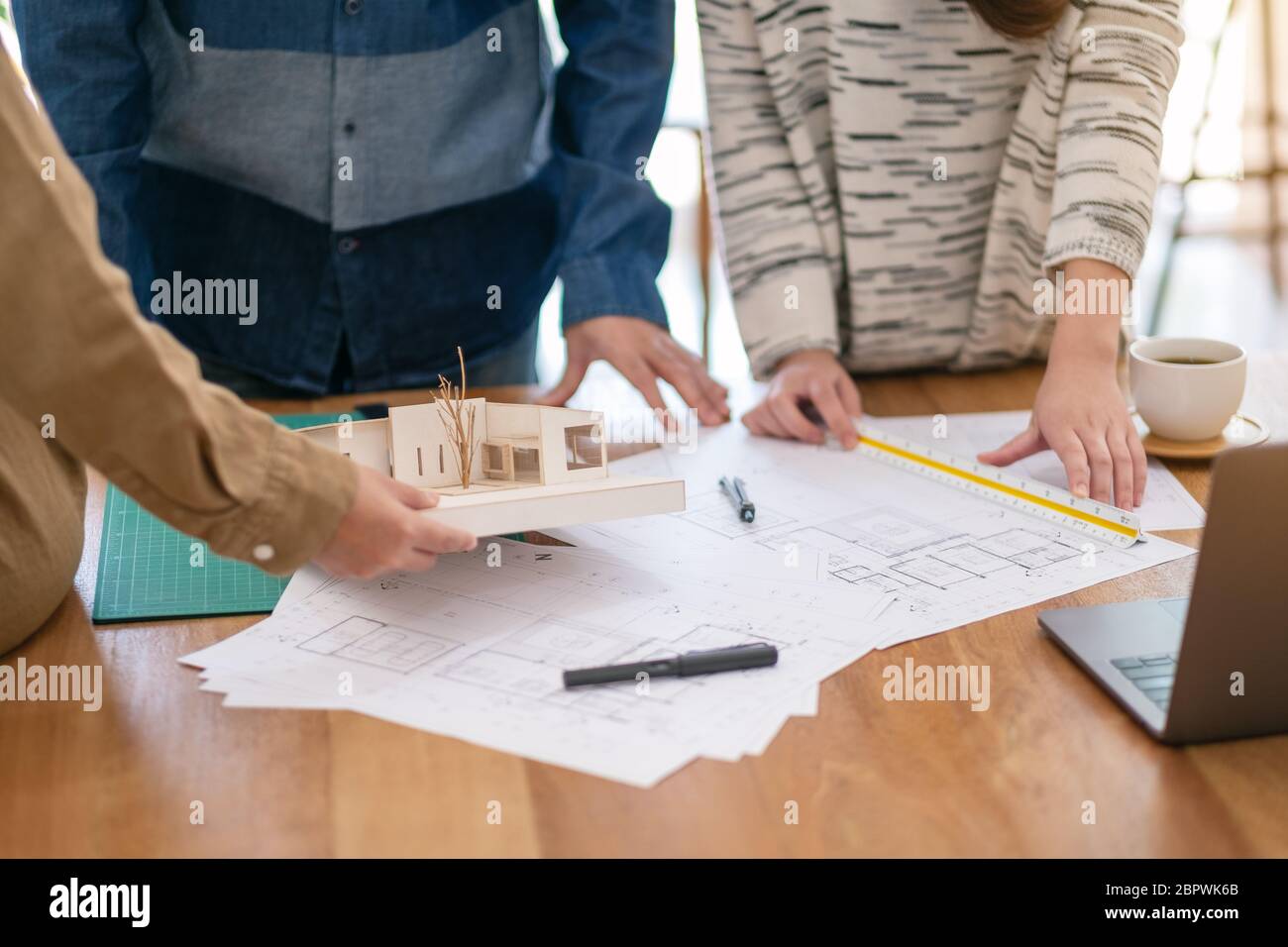 Group of an architect working and measuring scale of a mass model on ...