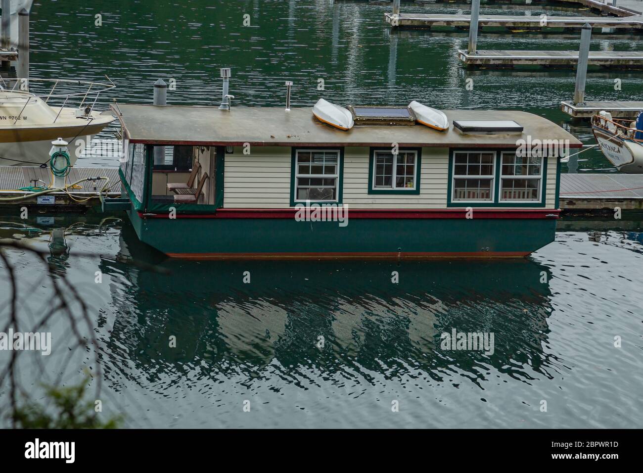 Green and white houseboat reflecting in the lake Stock Photo - Alamy