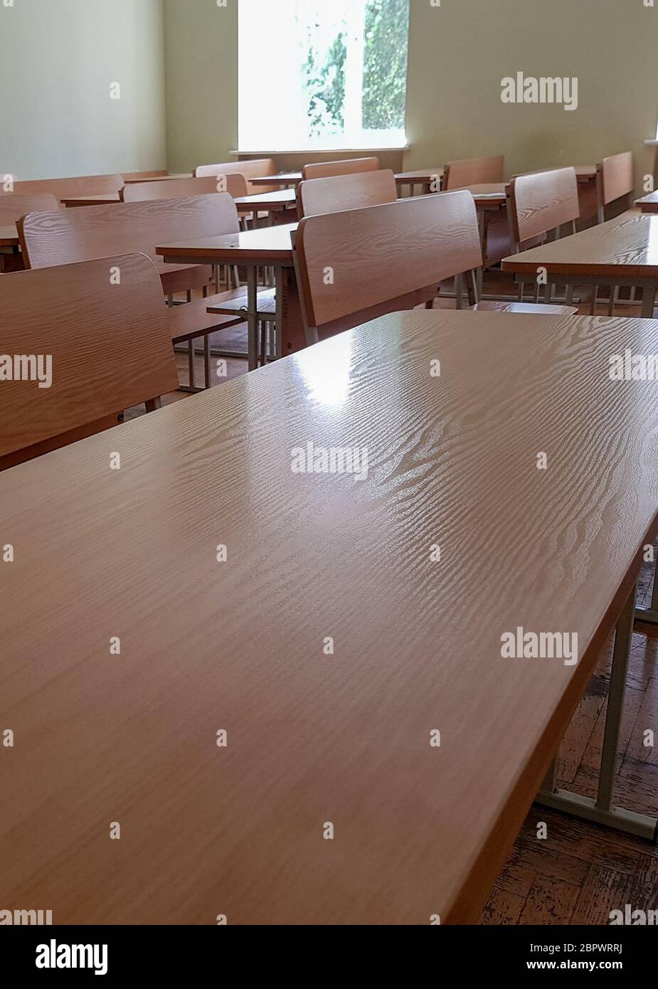 School classroom with three-row desks and large windows. Student ...