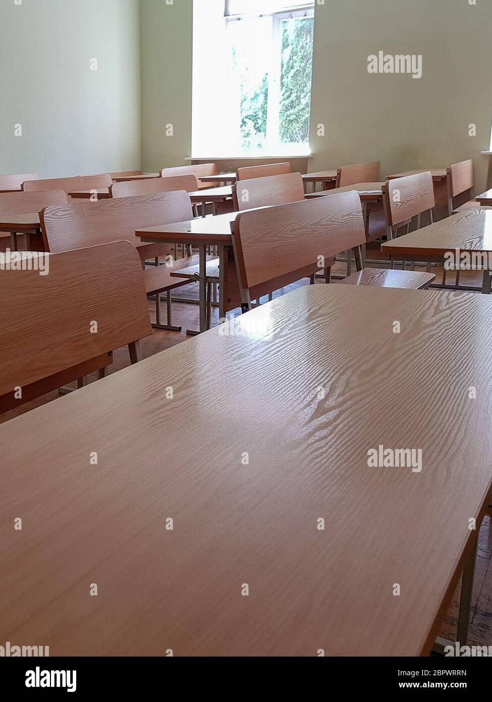 School classroom with three-row desks and large windows. Student ...