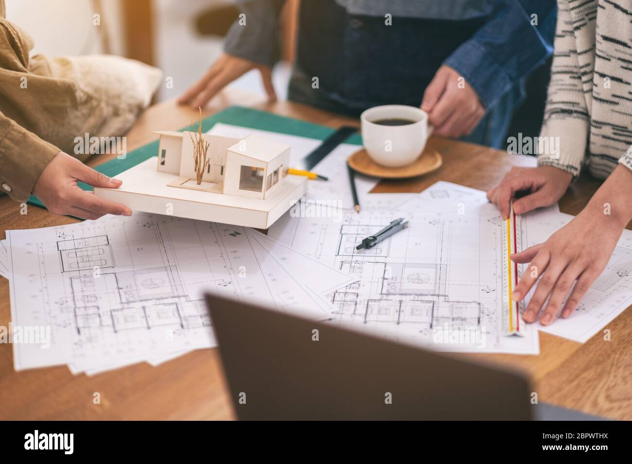 Group of an architect working and measuring scale of a mass model on ...