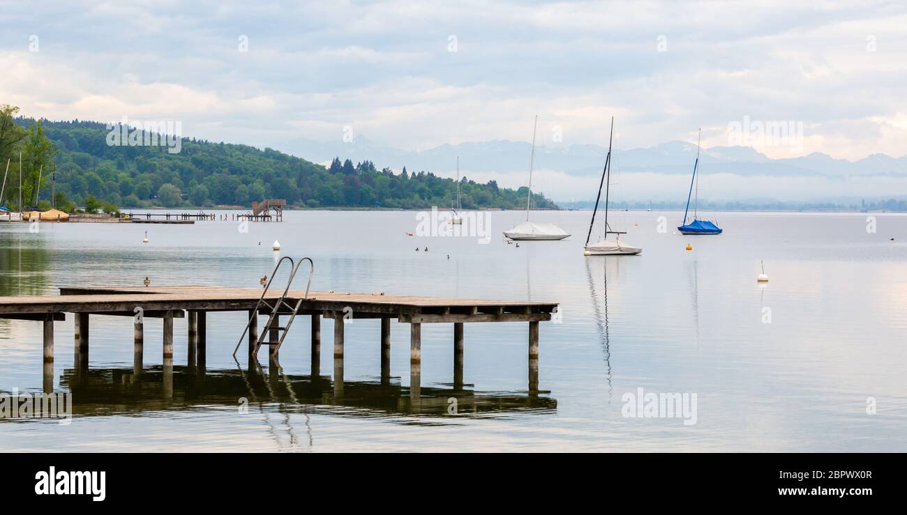 View on Ammersee (Lake Ammer) with a wooden pier, sailboats and - far ...