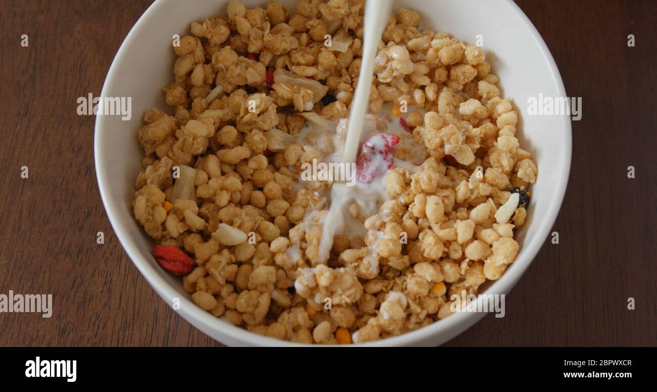 Adding milk into cereal Stock Photo - Alamy