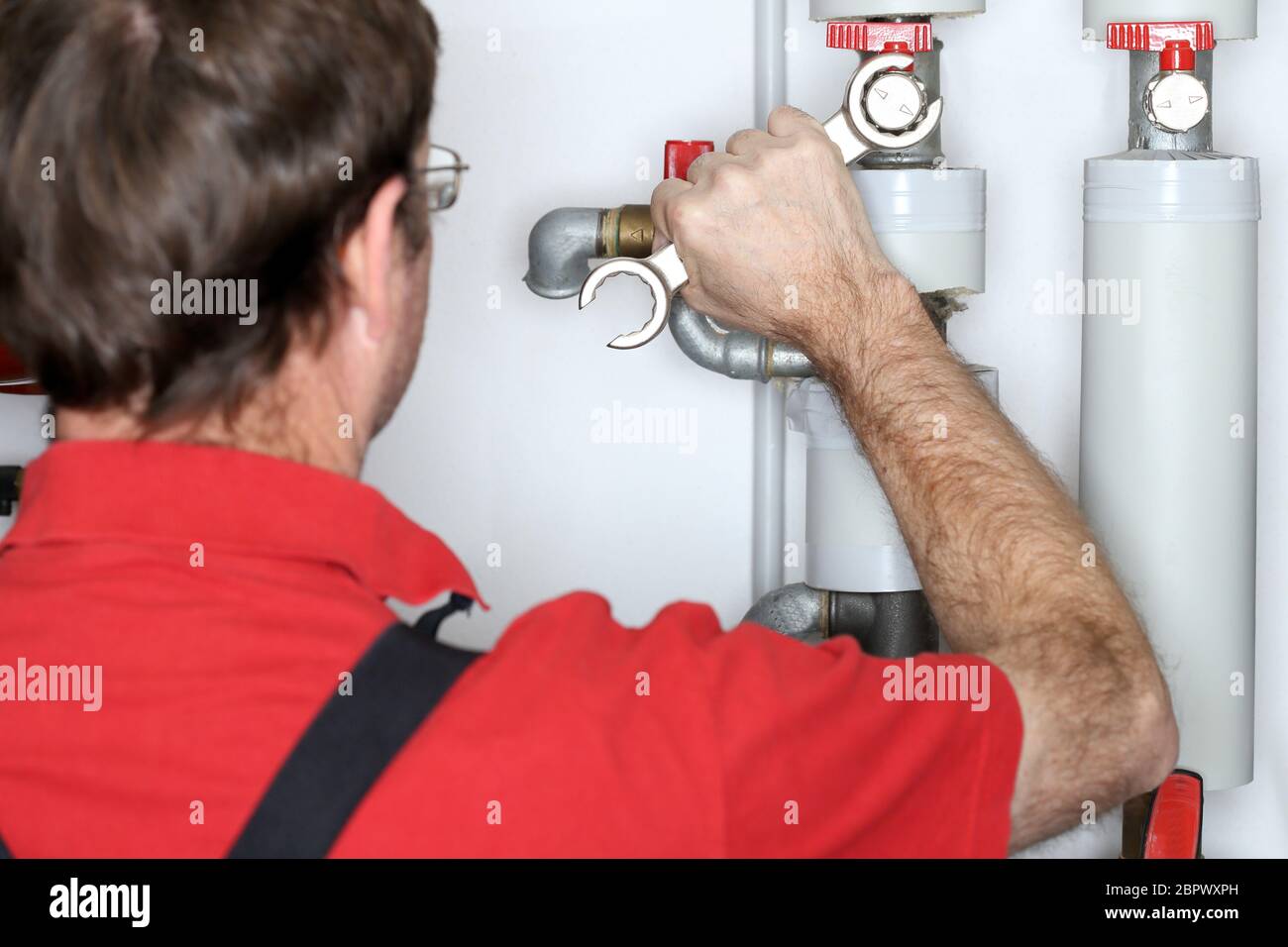 repair man with metal wrench is installing a valve Stock Photo - Alamy