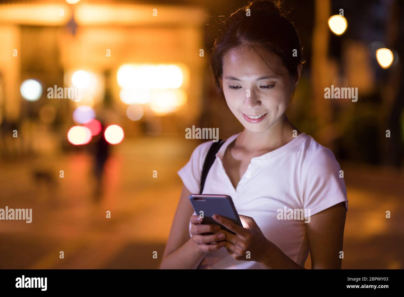 Woman use of mobile phone at night in the city Stock Photo - Alamy