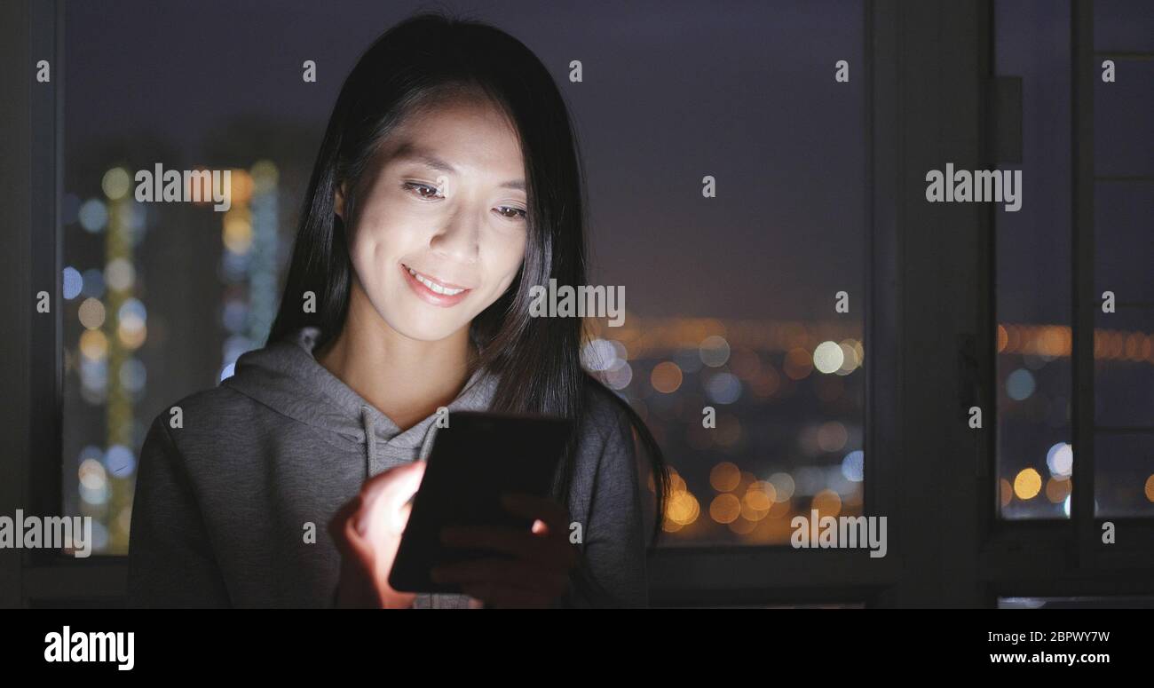 Woman watching in smart phone at night Stock Photo - Alamy