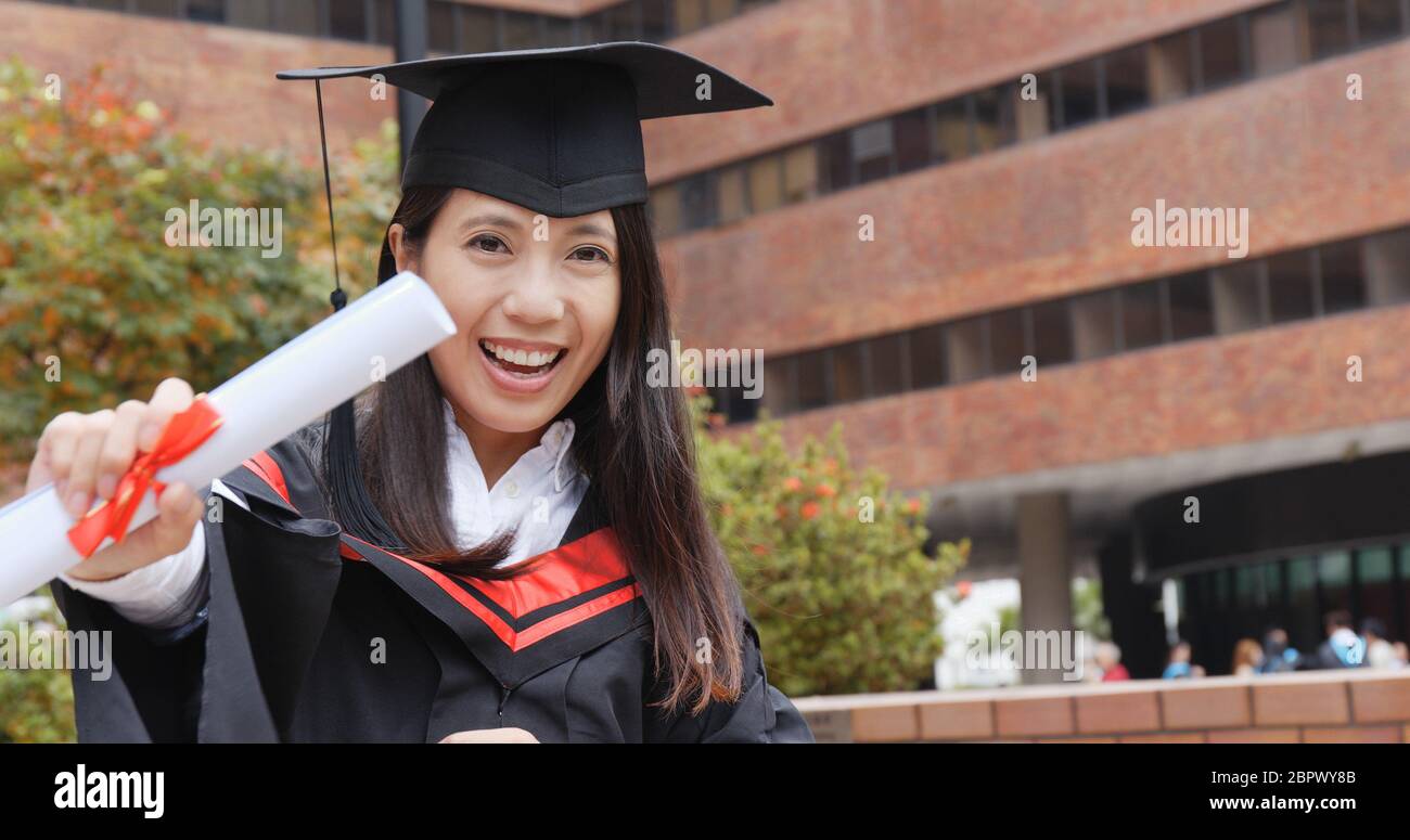 Excited Woman with graduation gown Stock Photo - Alamy
