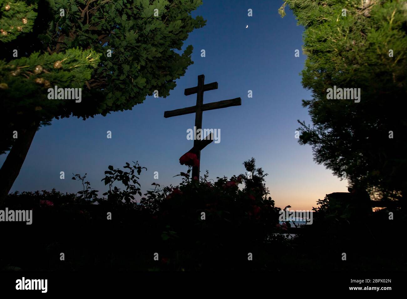 Huge wooden Orthodox eight-pointed cross against the sky after sunset ...