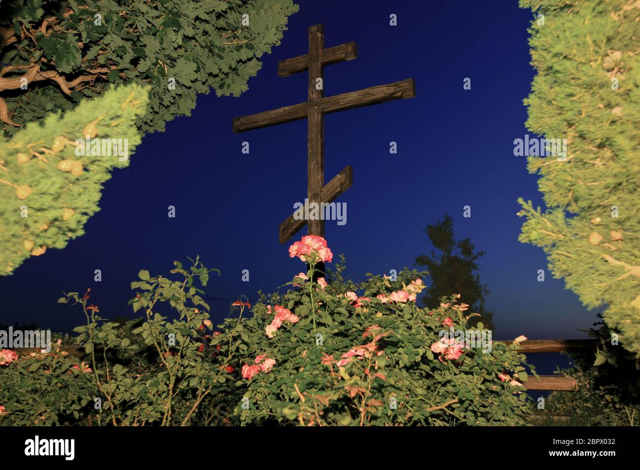 Huge wooden Orthodox eight-pointed cross against the sky after sunset ...