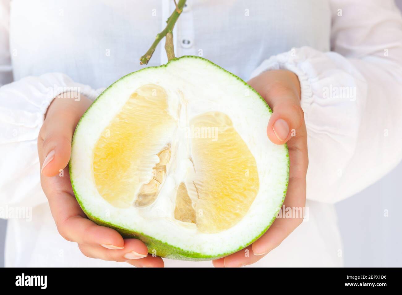 Woman holding healthy pomelo fruit cross section in hands Stock Photo ...