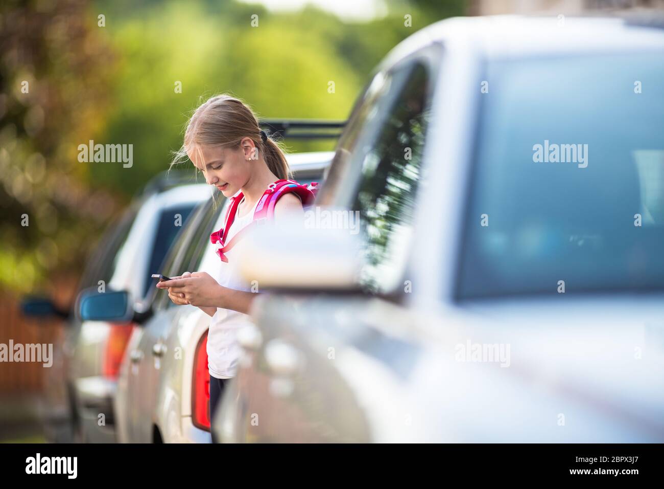 Cute little girl going home from school, looking well before crossing ...