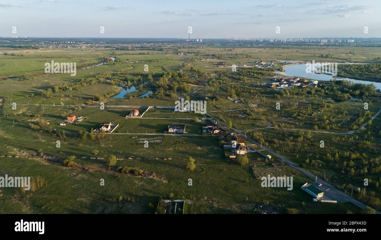 Aerial view of fields with sparse buildings in small private houses and ...