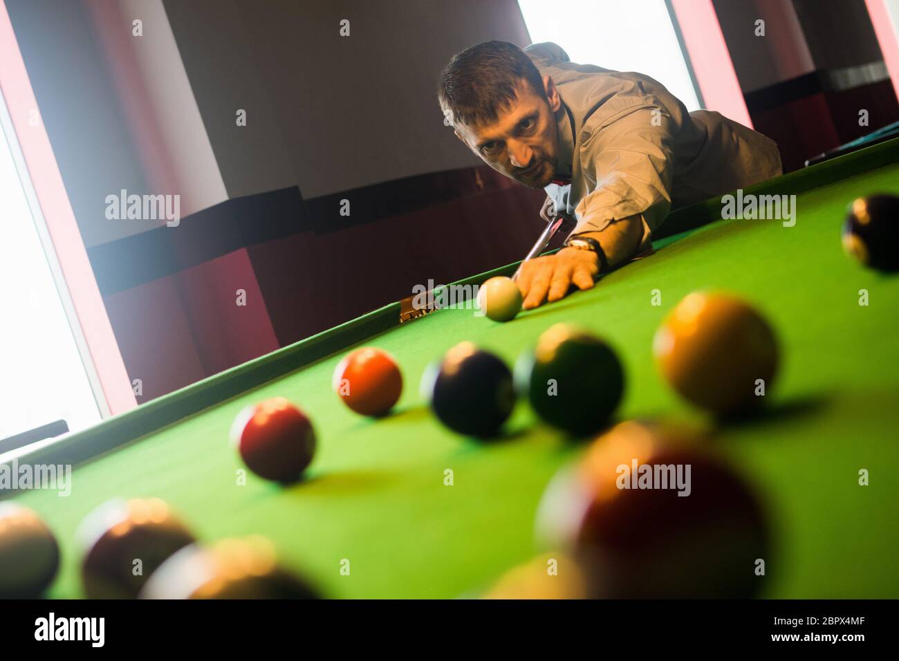 The player is concentrate to play billiards and to shoot the billiard ...