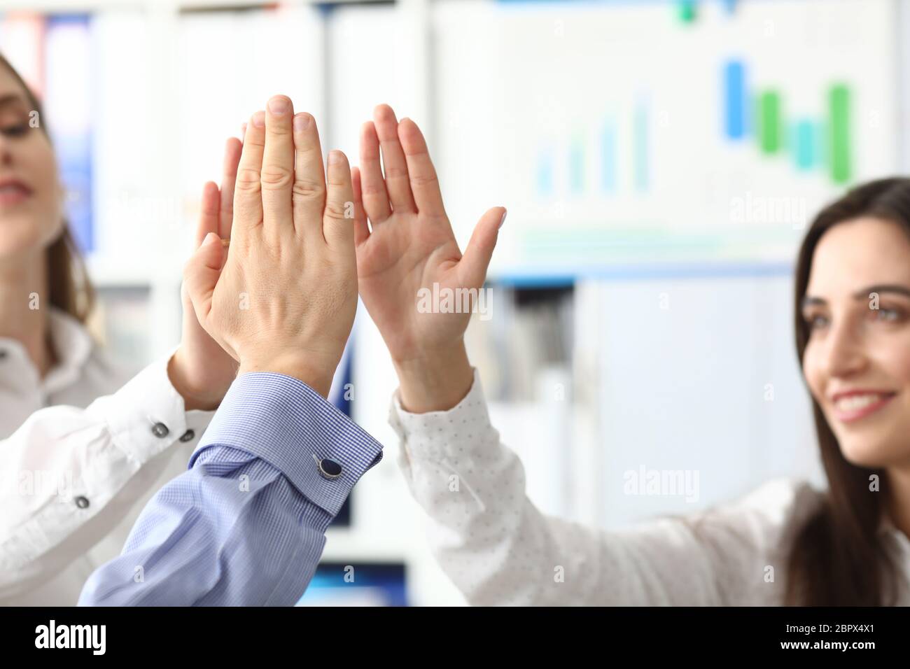 Joyful colleagues high five Stock Photo - Alamy