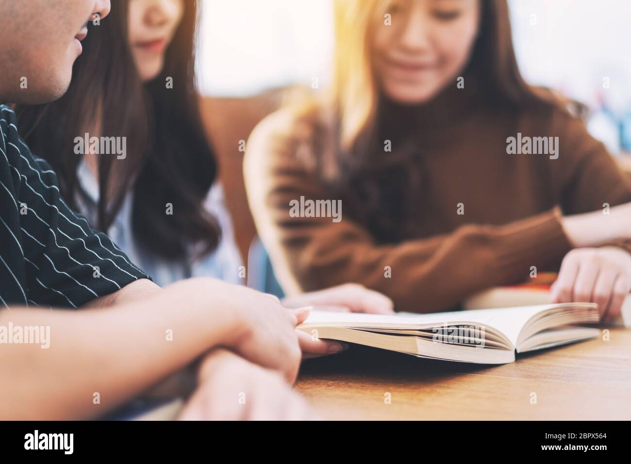 Group of young people enjoyed reading the same book together Stock ...