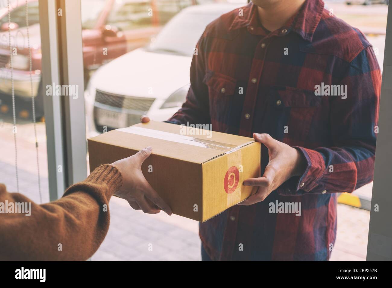 woman receiving parcel box from delivery man at the house's door Stock ...