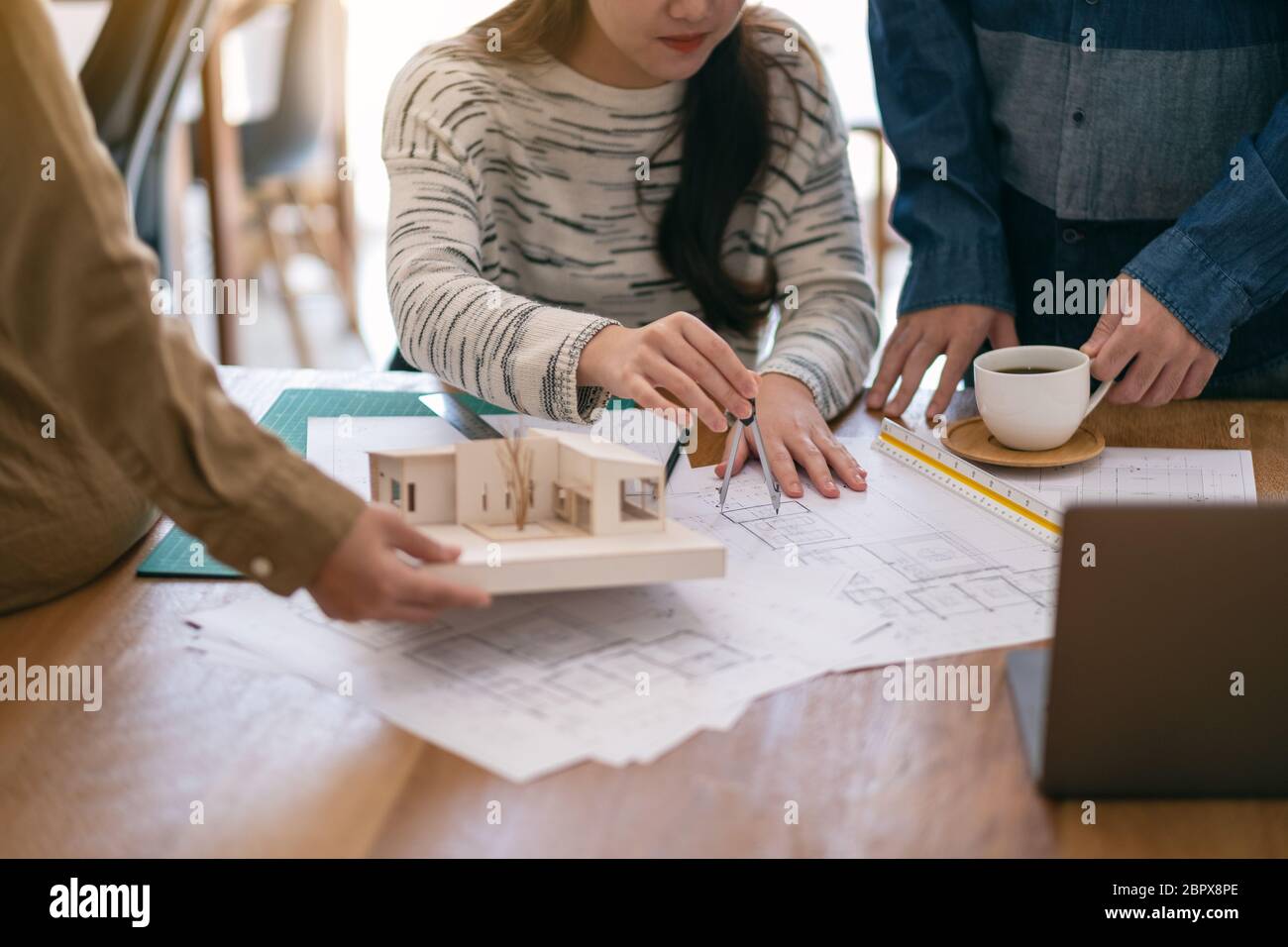 Group of an architect working and measuring scale of a mass model on ...