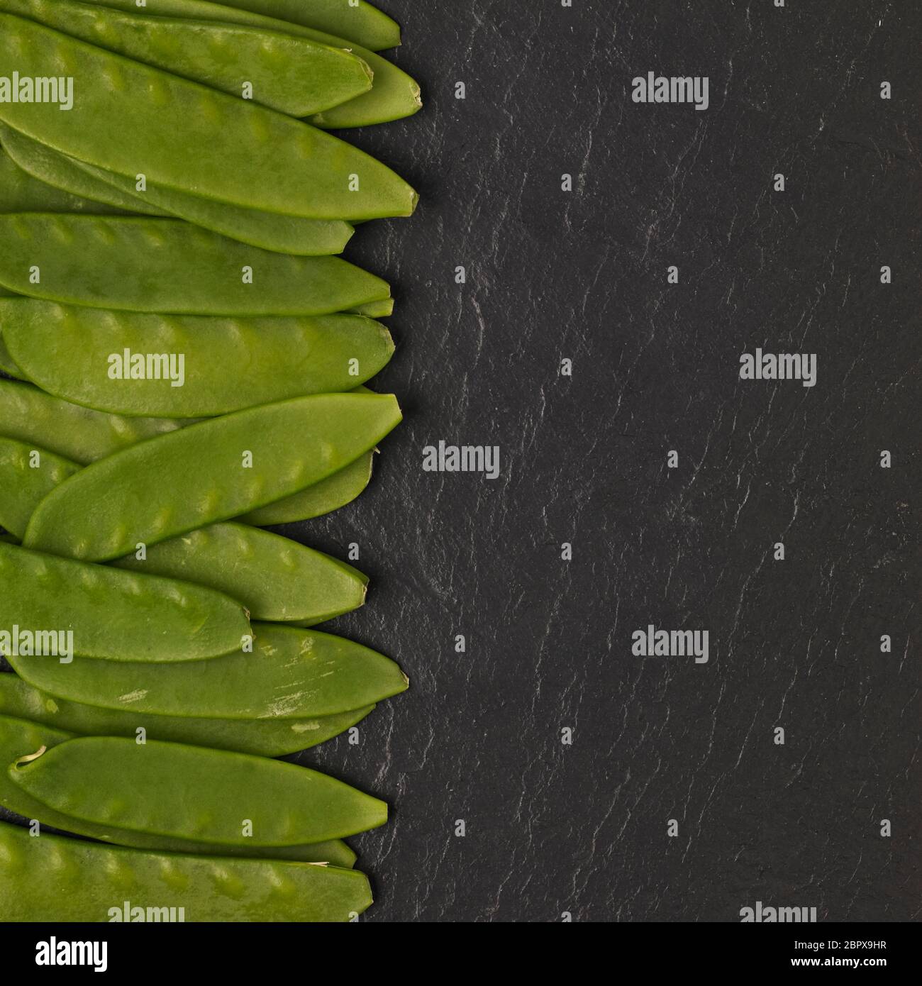 Fresh Mange Tout on slate background Stock Photo - Alamy