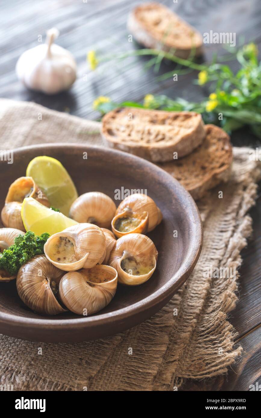 Bowl of cooked snails Stock Photo - Alamy